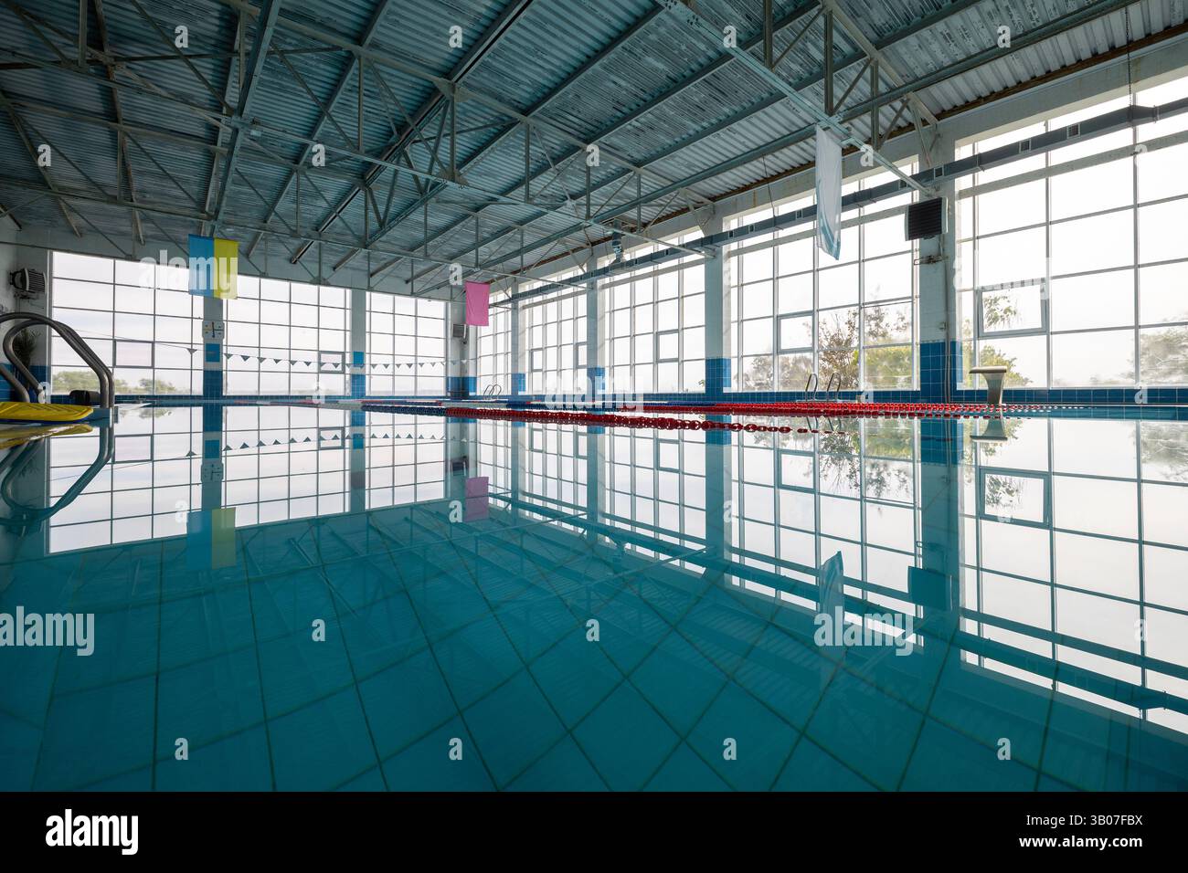 Indoor five-lane swimming pool with clear water, lane markers, and a ...