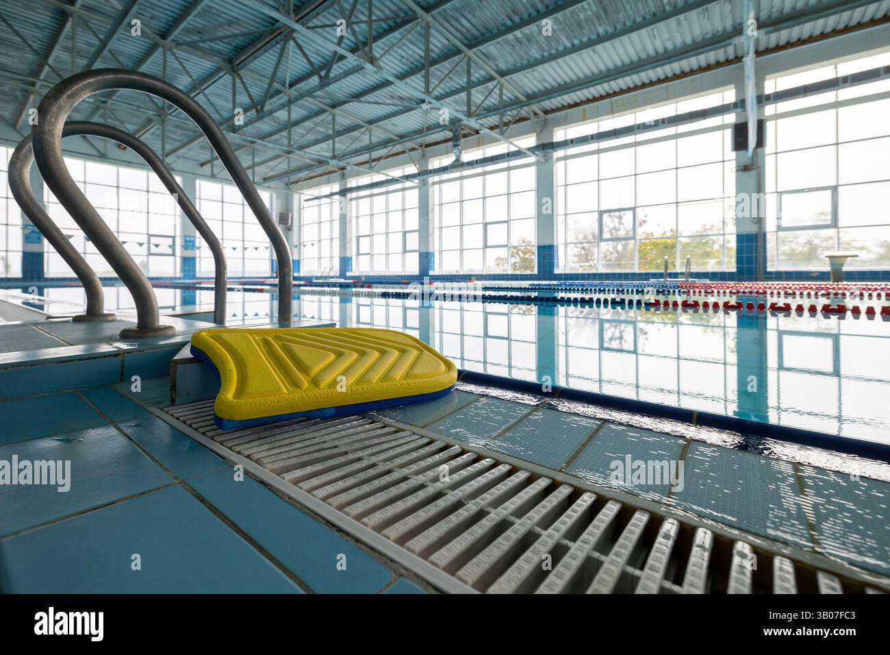 An indoor swimming pool with clear water features lane markers. A ...