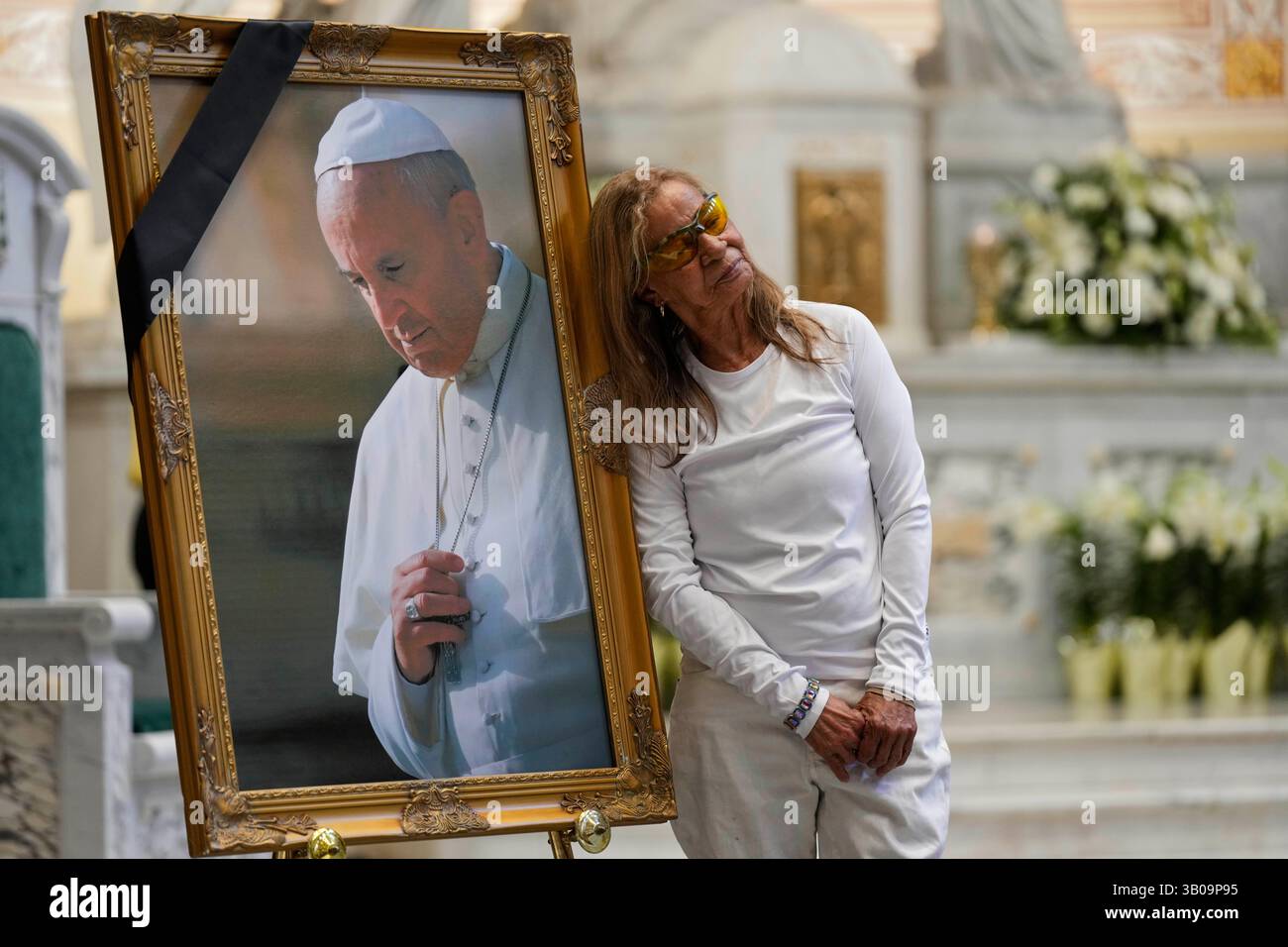 Maureen Boyd leans against a portrait of the late Pope Francis after a ...