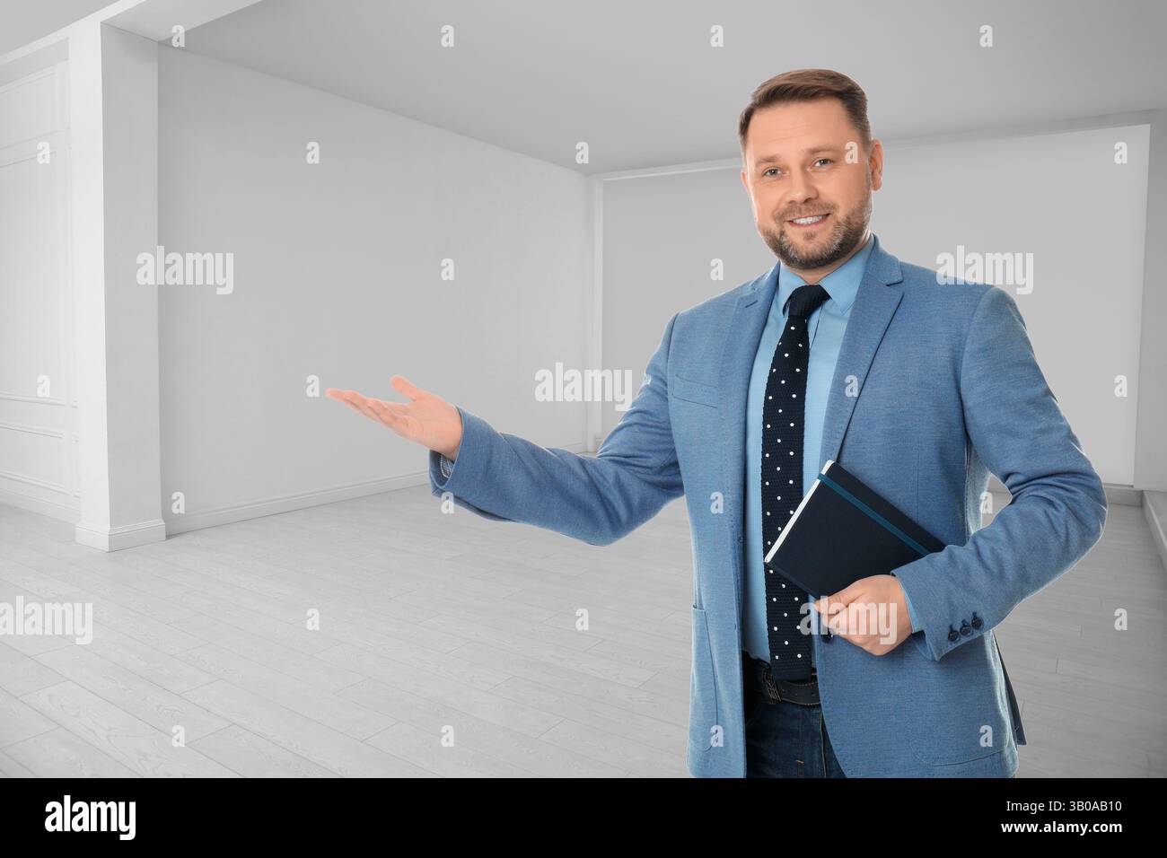 Real estate agent with notebook in room Stock Photo - Alamy