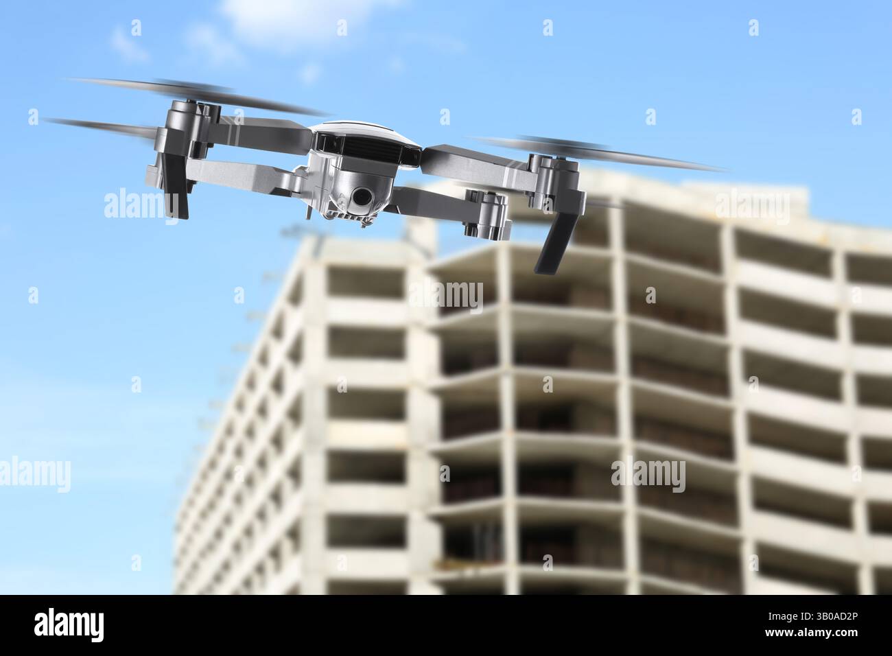 Drone with camera flying near unfinished building. Unmanned aerial ...