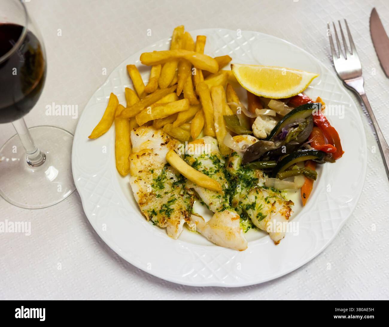 Plate contains fried pink cusk-eel fillet, complemented by French fries ...