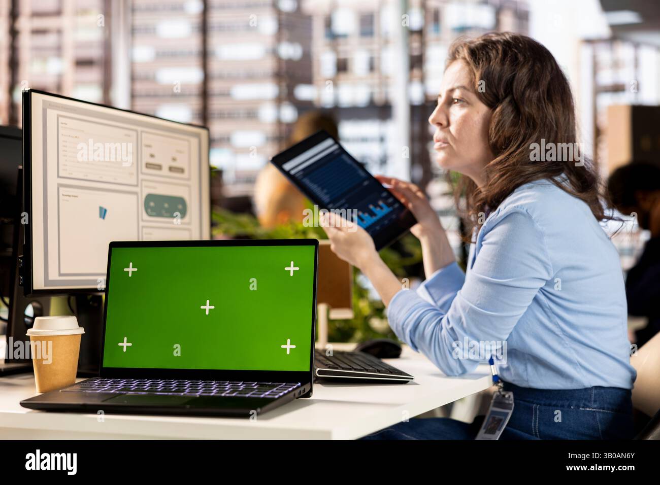 Woman employee examines business data next to mockup display, working ...