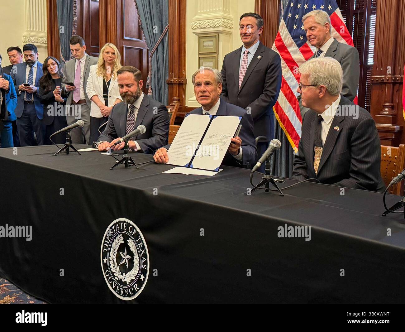 Texas Gov. Greg Abbott, center, holds a newly signed bill creating the ...