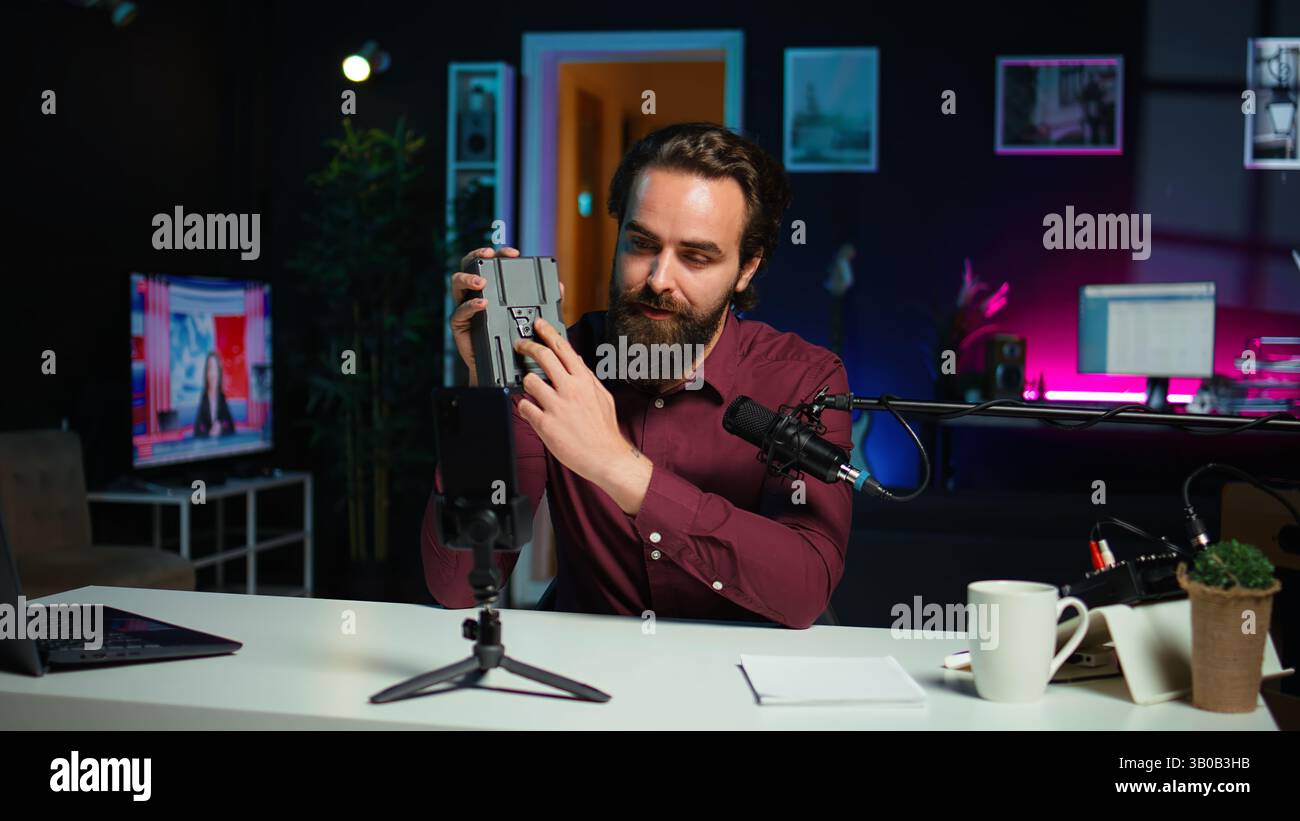 Tech guru presenting V mount battery, filming technology review using ...
