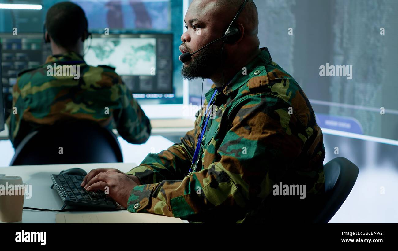 Military control room features army personnel monitoring surveillance systems, soldiers ...
