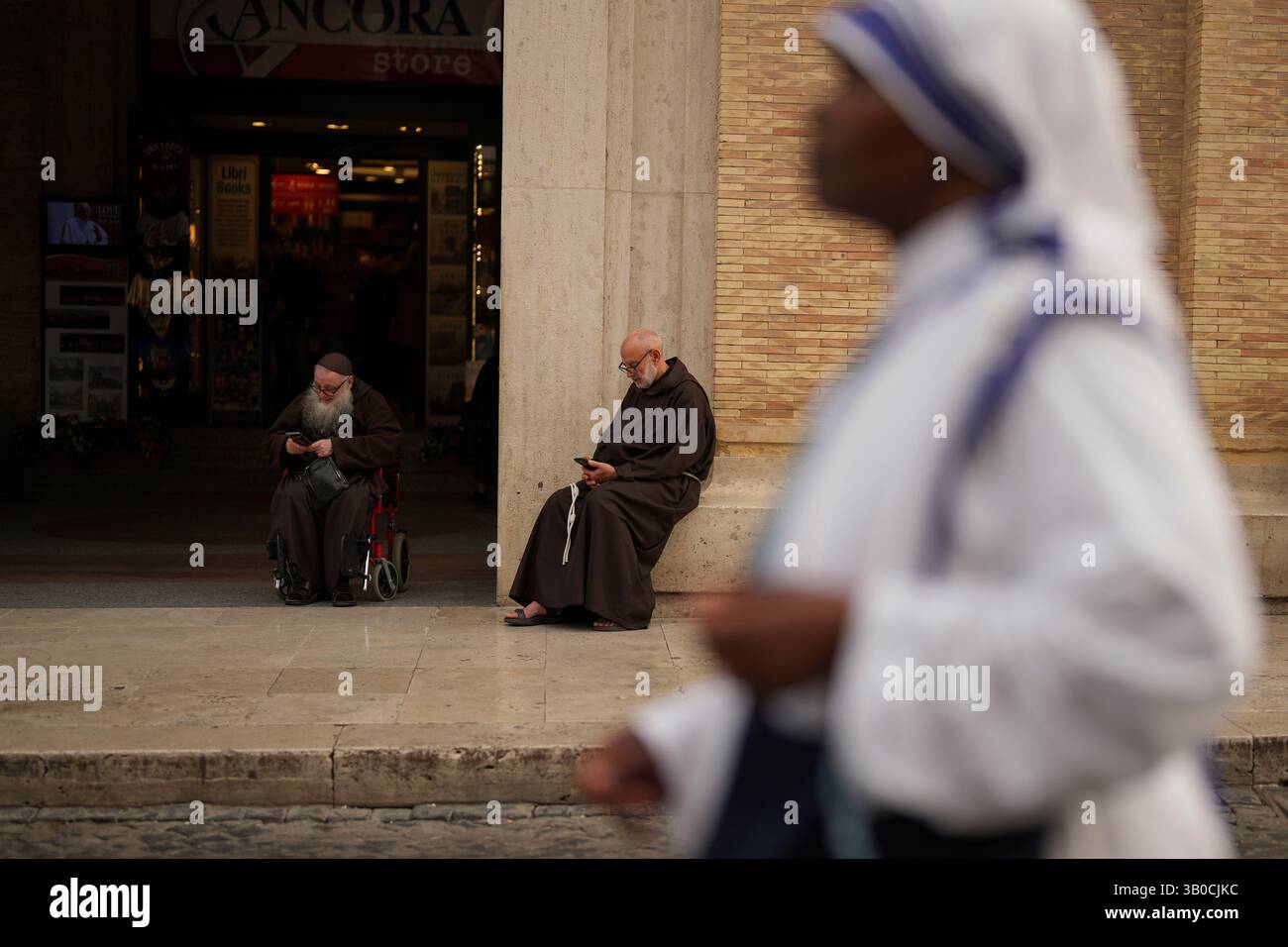 Two friars look at their cell phones near St. Peter's Square at the ...