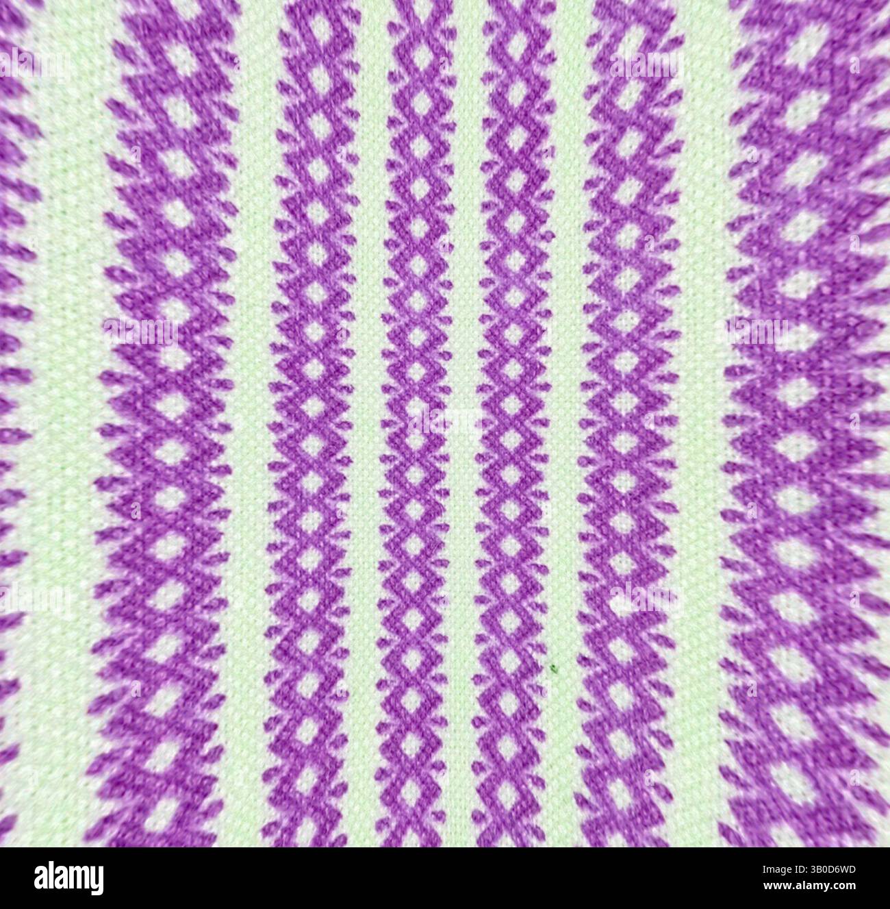 A textured fabric featuring a repeating pattern of purple designs ...