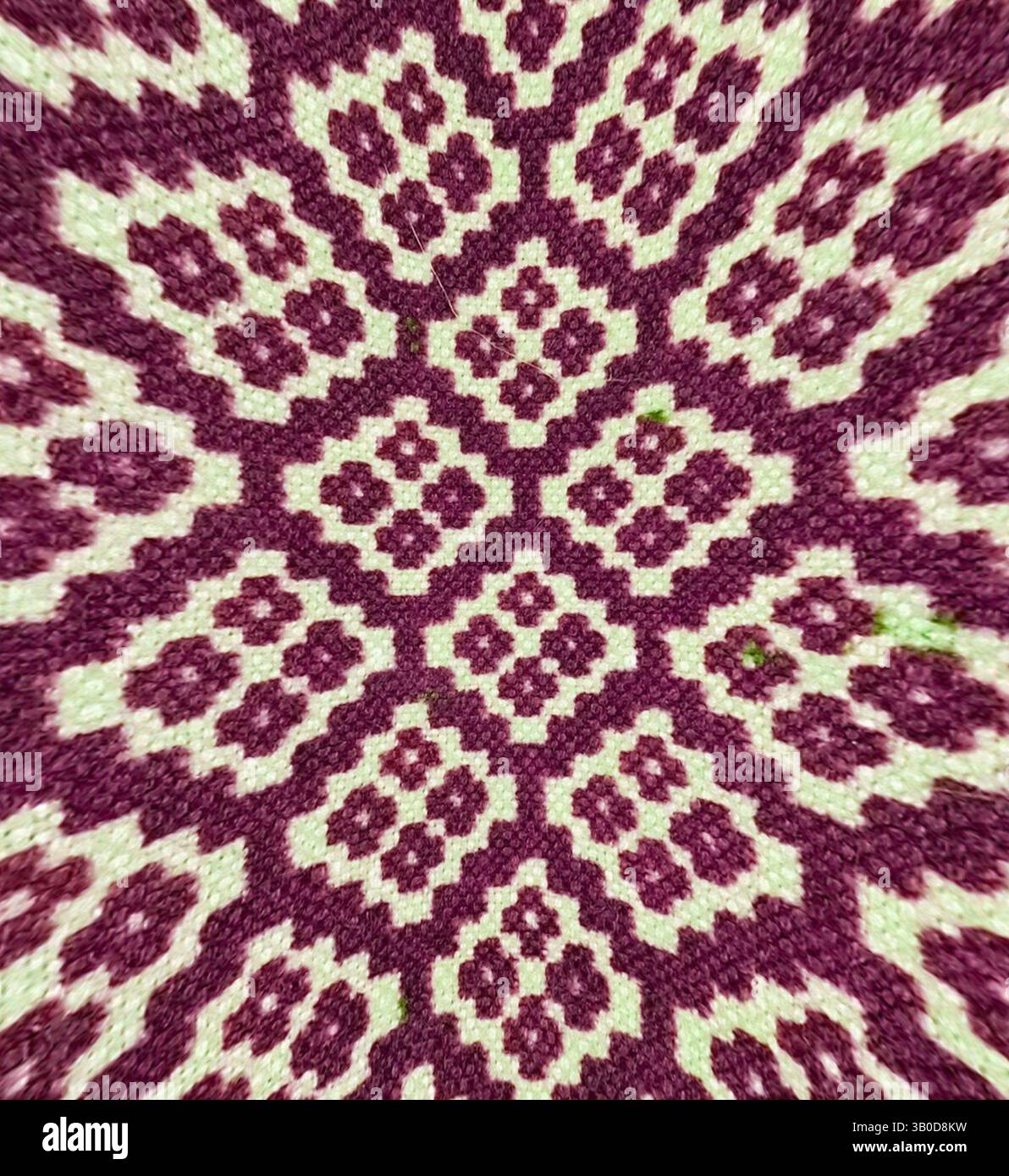 A richly patterned textile features intricate geometric shapes and ...