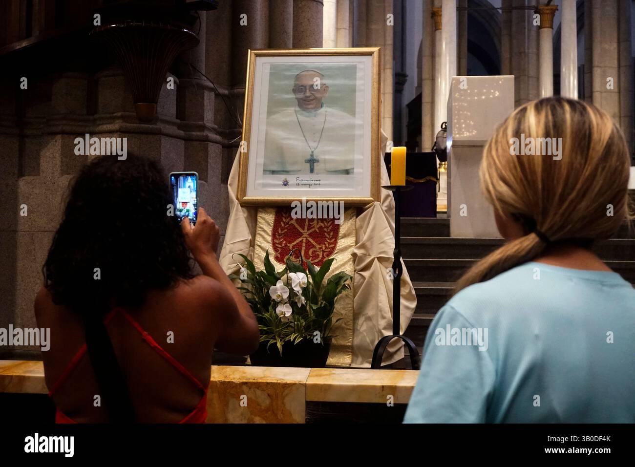 Believers pray after the death of Pope Francis in the Se Cathedral on Wednesday, April 23, 2025 ...