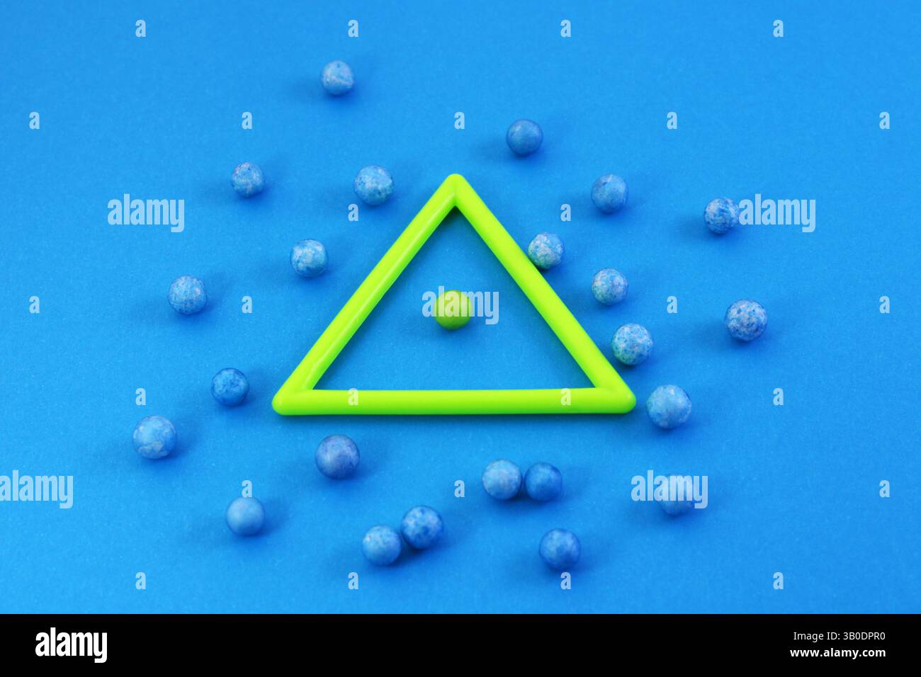 Green triangle separates sphere of the same color Stock Photo - Alamy