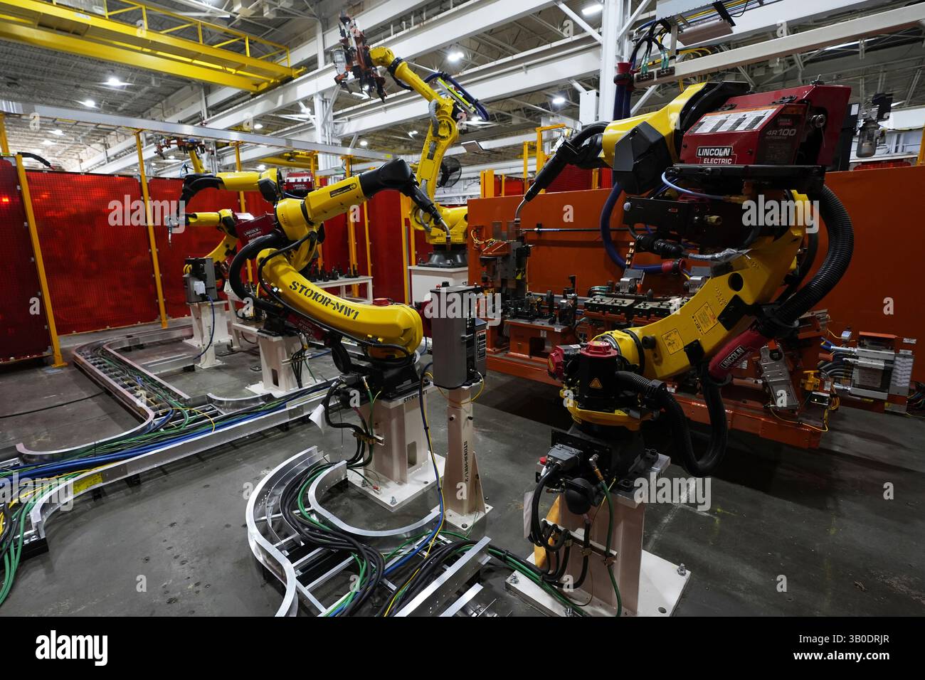 Robotic arms are shown in a sub cell of a crush horn assembly line at a ...