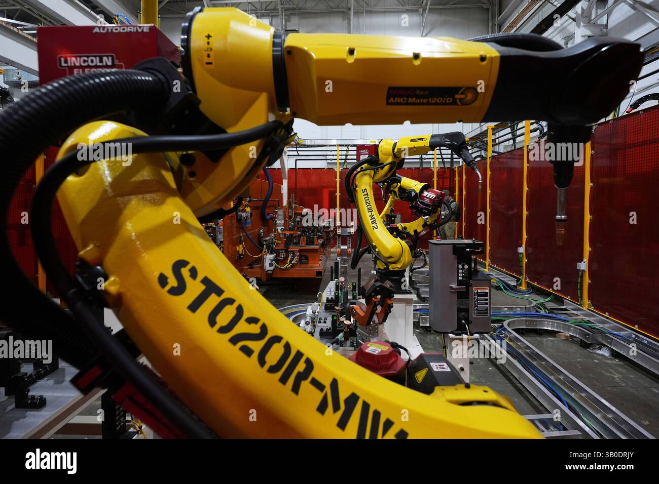 Robotic arms are shown in a sub cell of a crush horn assembly line at a ...