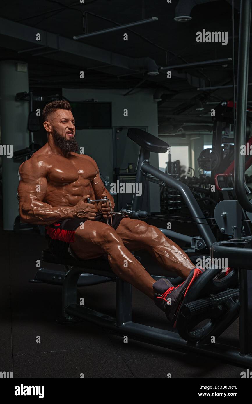 muscular man performs workout on rowing machine in modern gym setting ...
