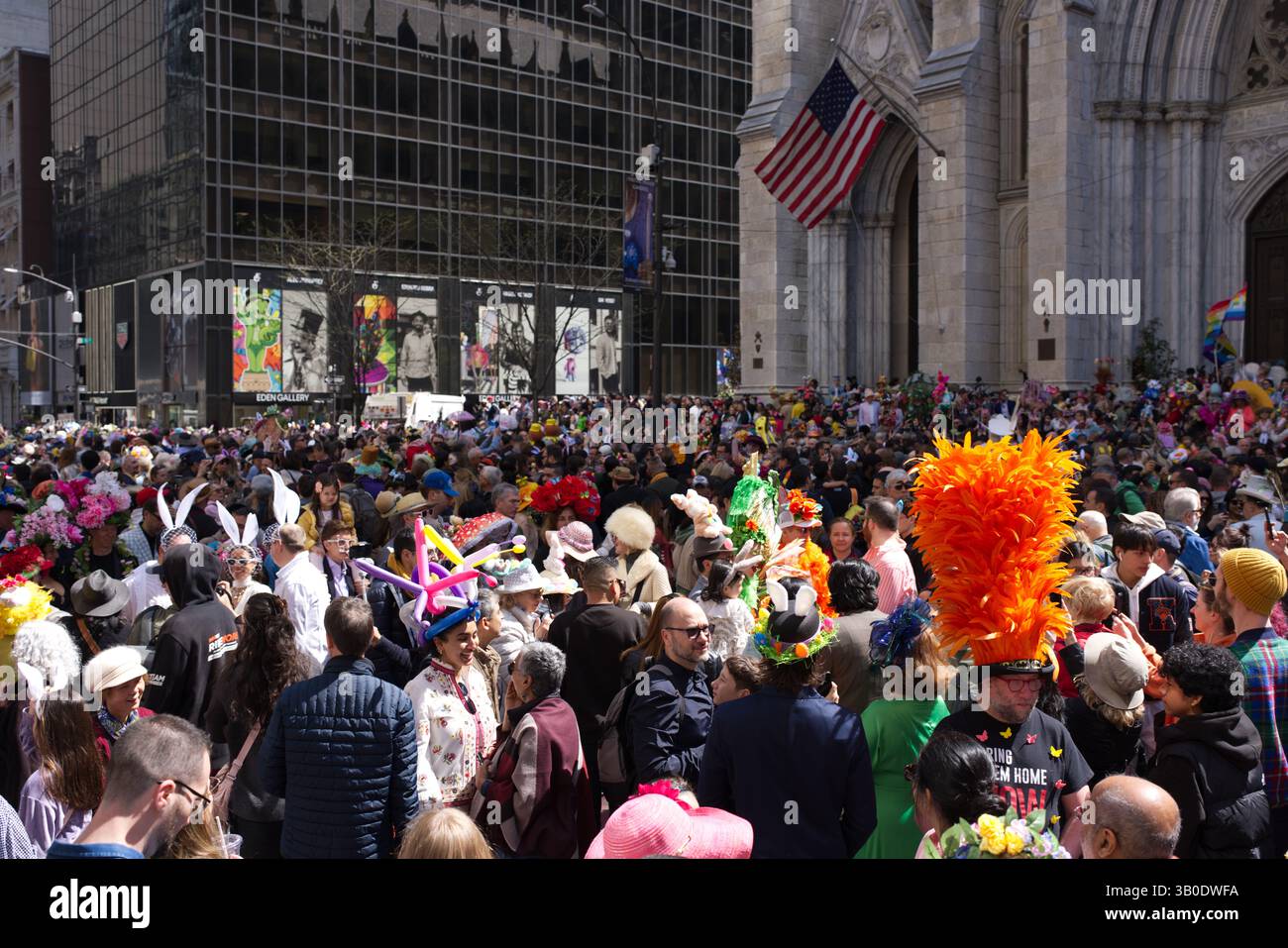 A large crowd of people wearing elaborate hats participate in an Easter ...