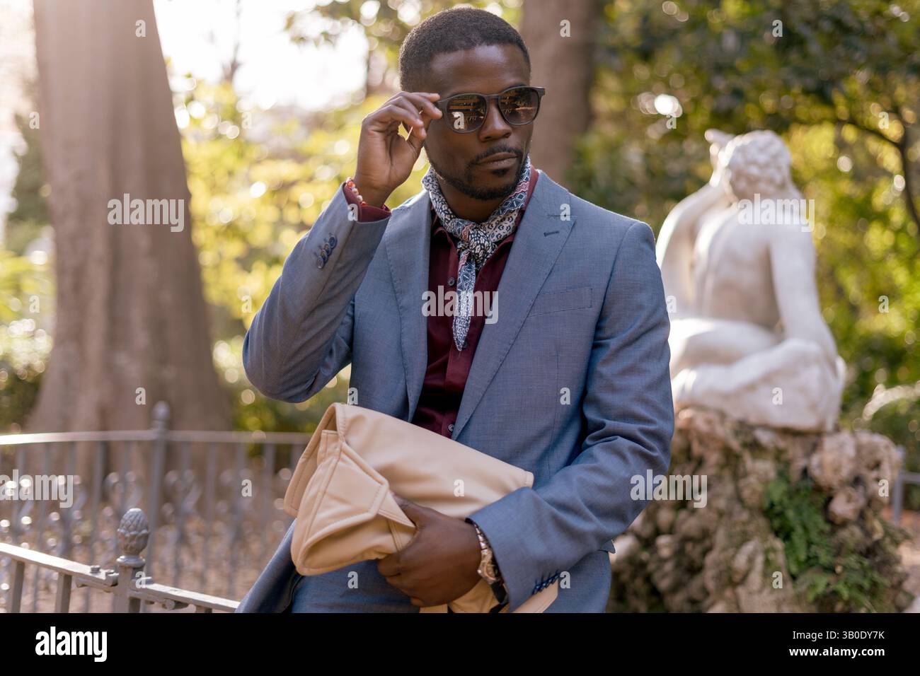 A Stylish Man Dressed in Smart Attire Wearing Sunglasses in a Beautiful ...