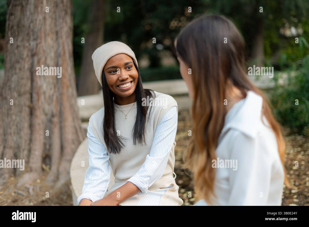 Two friends are engaging in a delightful outdoor conversation filled ...