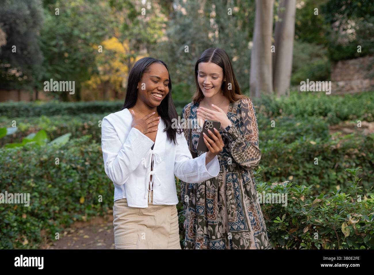 Two friends are enjoying a wonderful nature walk together while sharing ...