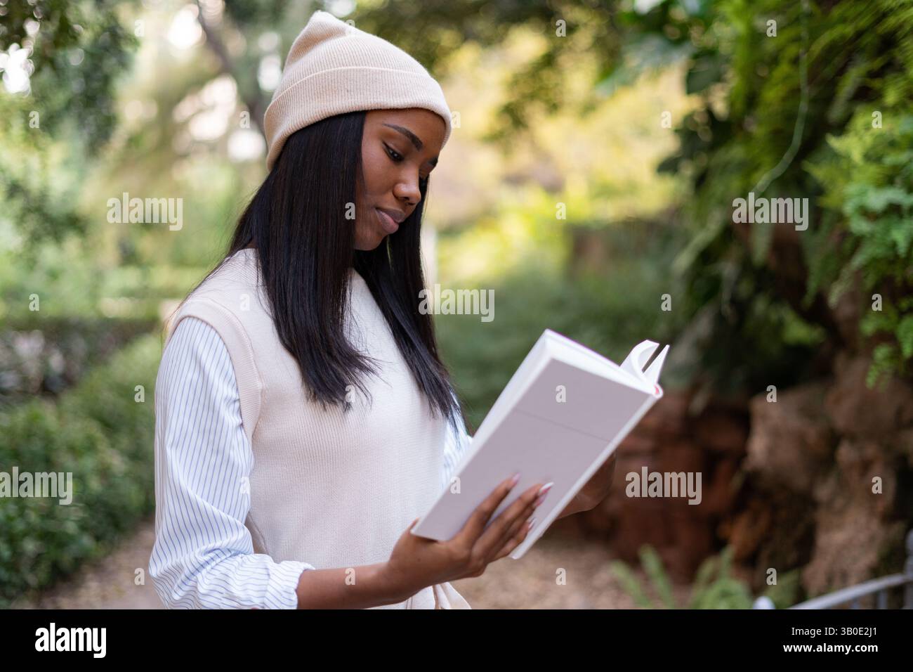 A woman immersed in the joy of reading, enjoying the tranquil beauty of ...