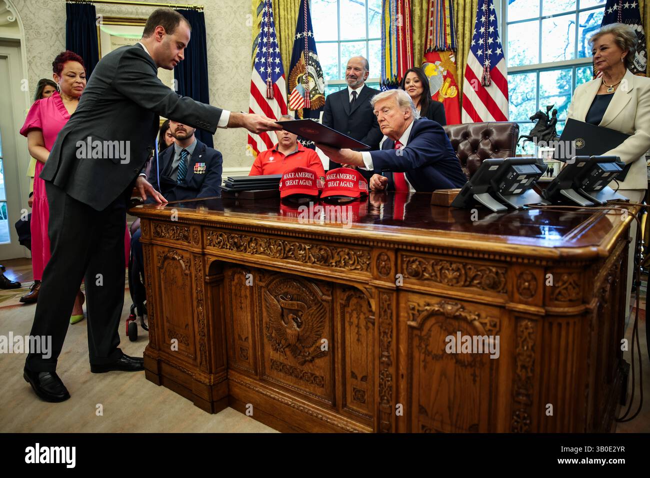 Staff Secretary Will Scharf hands United States President Donald Trump ...