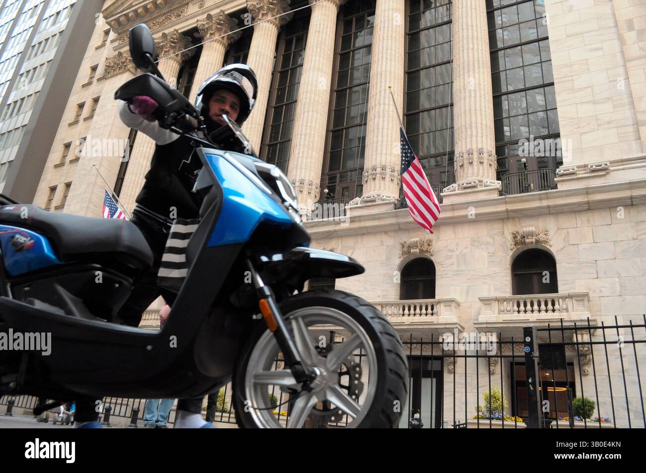 A person pushes a moped past the New York Stock Exchange in the ...
