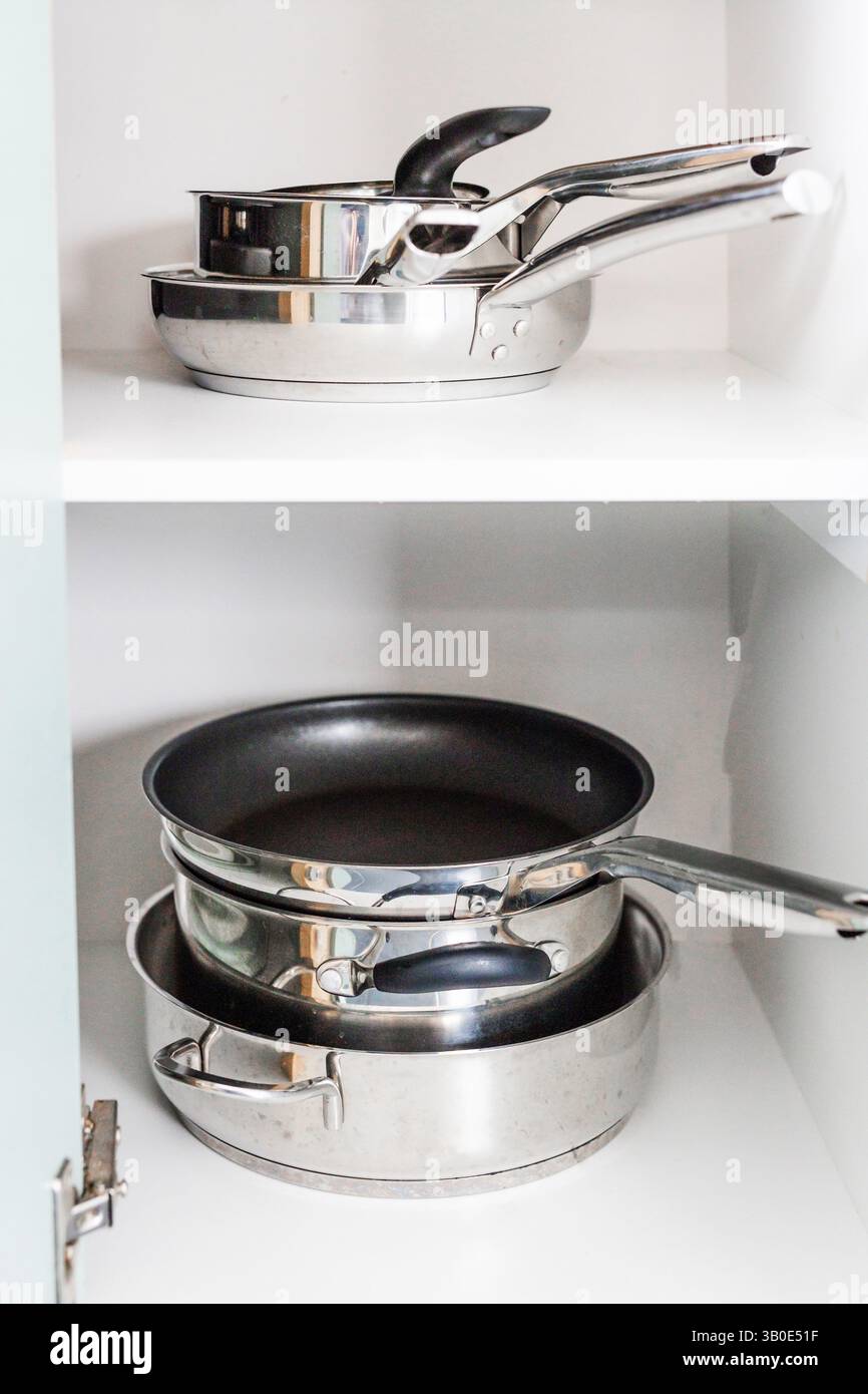 tidy decluttered kitchen cabinet shelves with pots and pans piled up ...