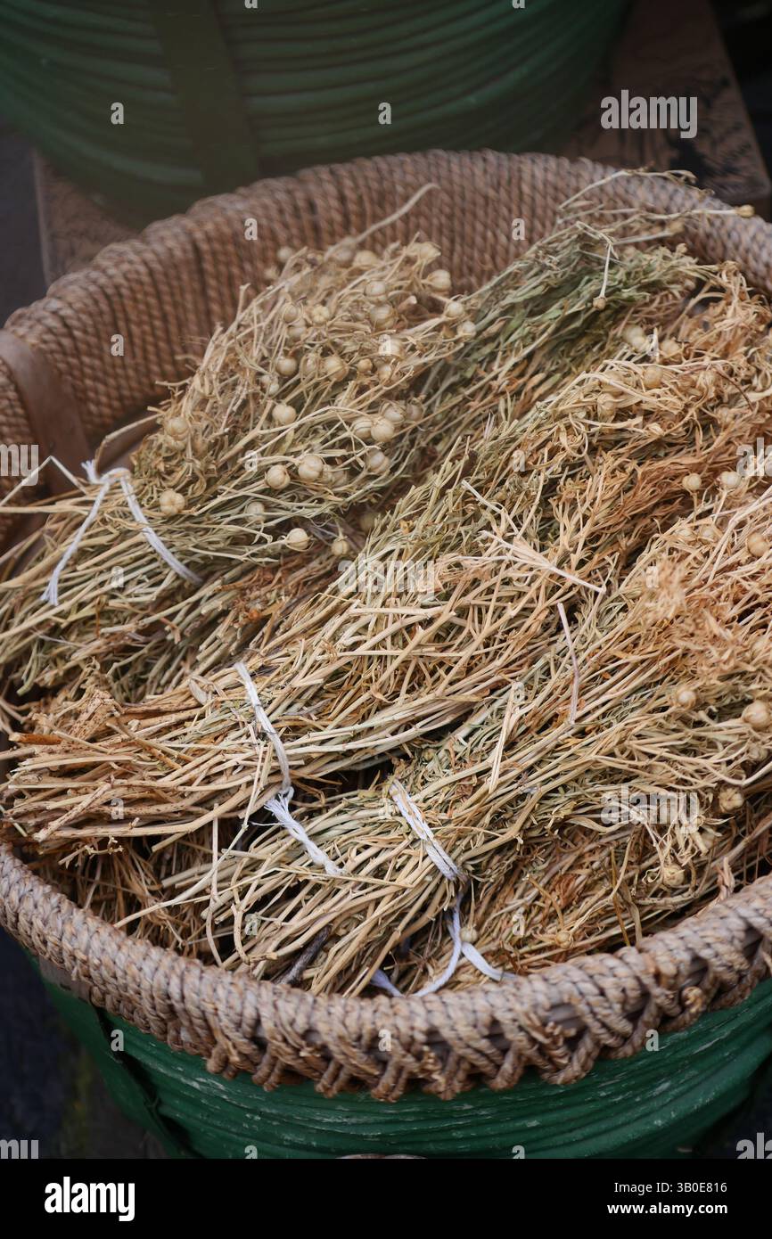 Dried herbal bundles in a woven basket at a local market Stock Photo ...