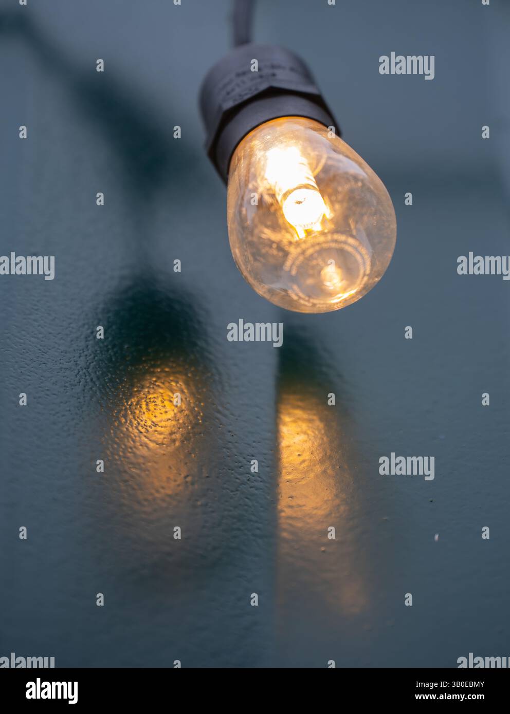 Vertical image of electric light bulb lit light is shining and ...