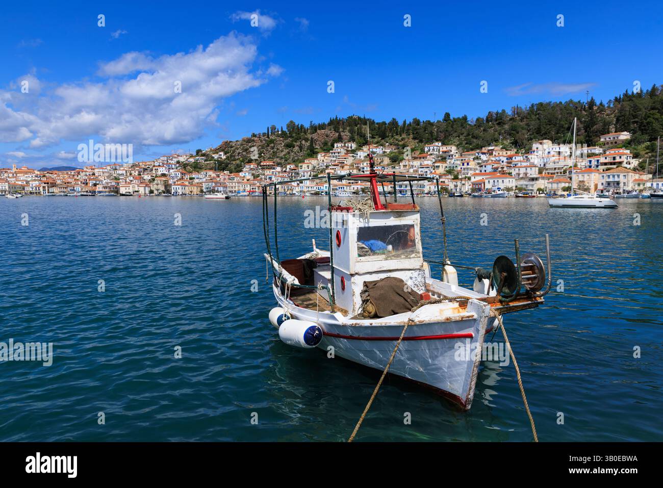 Traditional fishing boat floating in the blue sea near the colorful ...