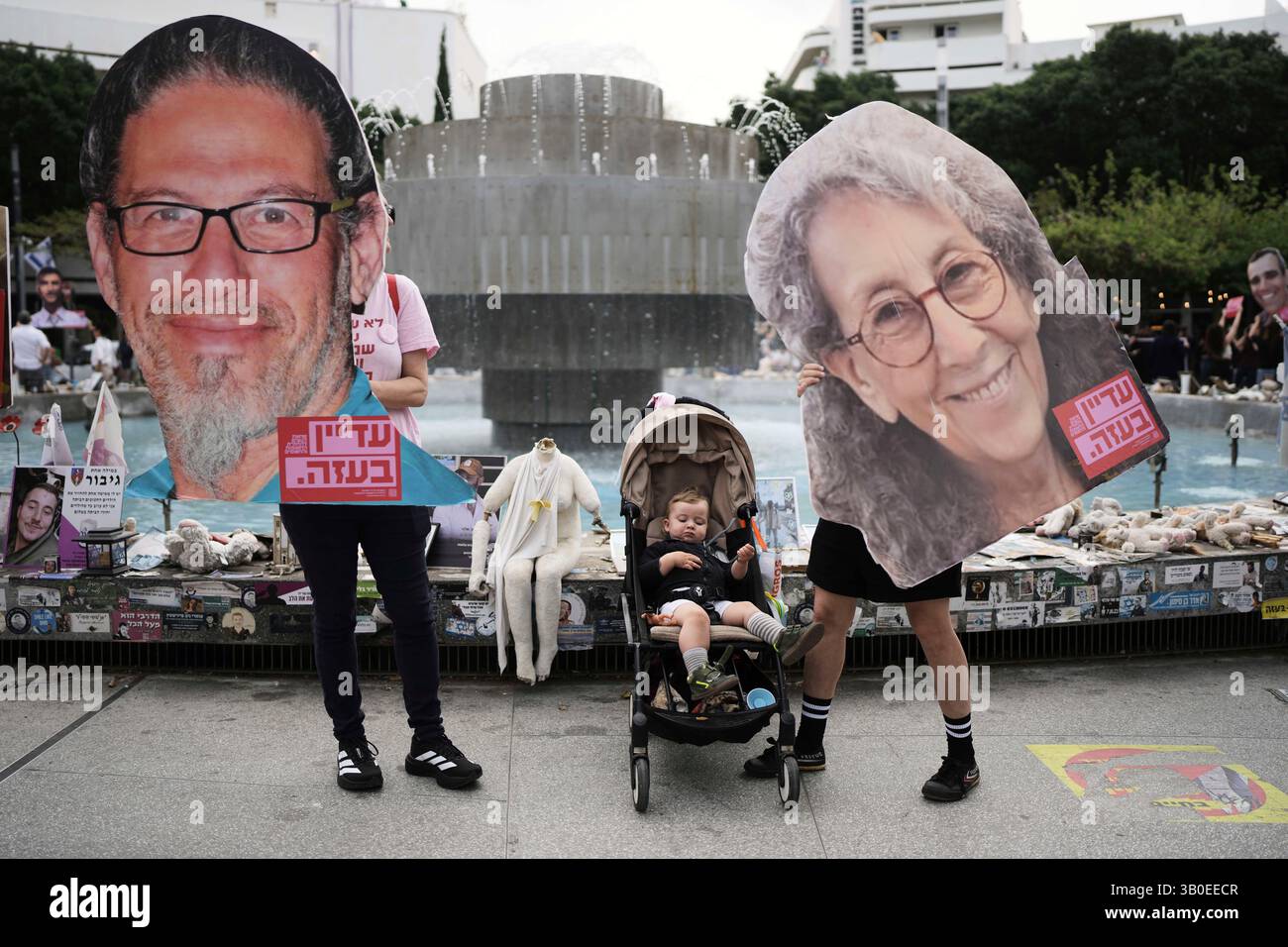 People hold photos of hostages held in Gaza, ahead of a two-minute ...