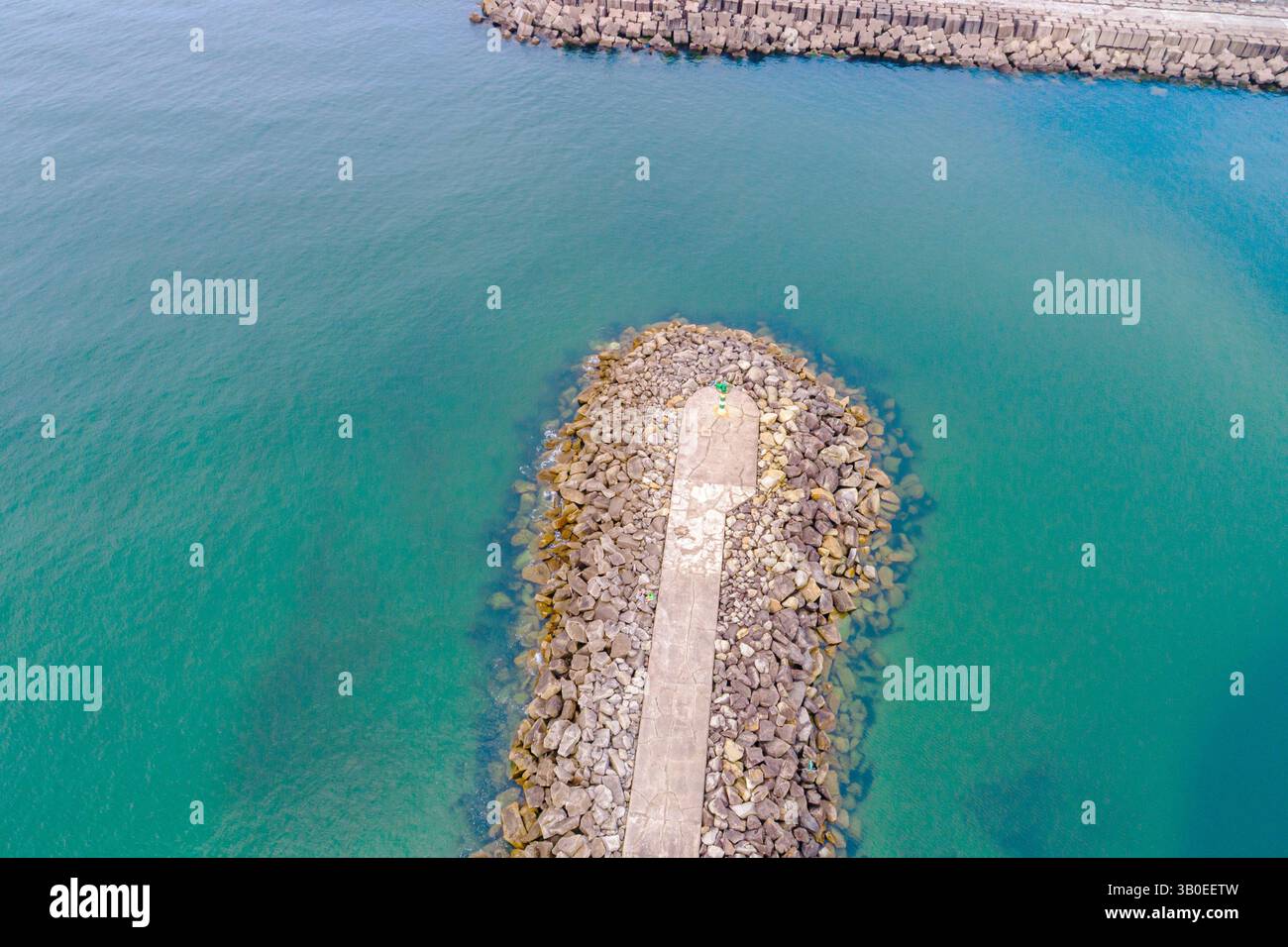 aerial view of a rocky breakwater extending into the sea drone shot of ...