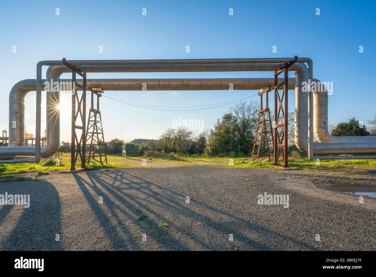 Pipeline of a geothermal power plant at sunset in Larderello, Tuscany ...