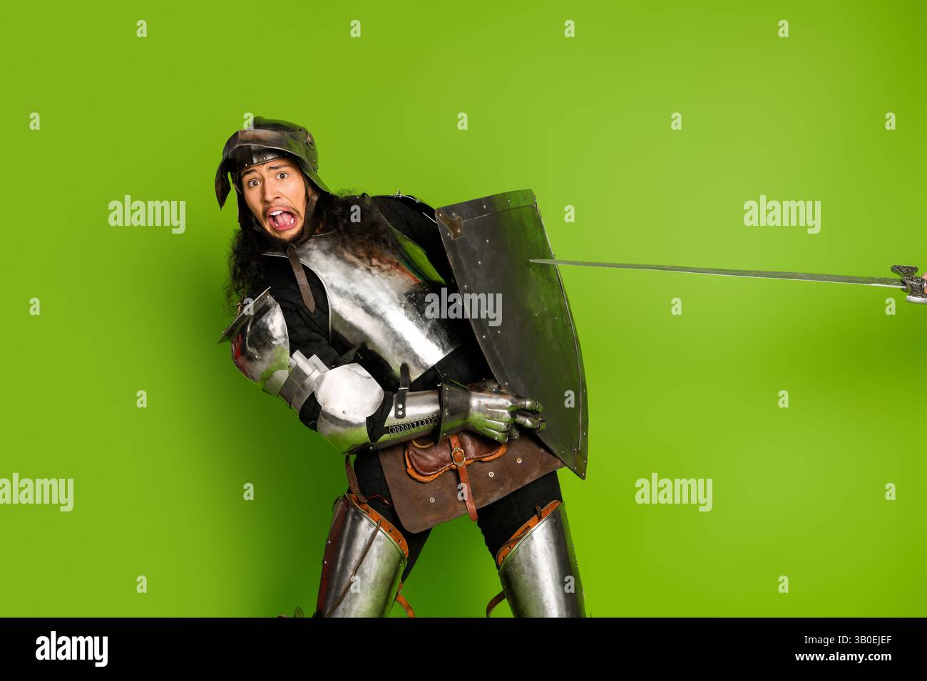 Young man in medieval knight armor with shield and sword on bright ...