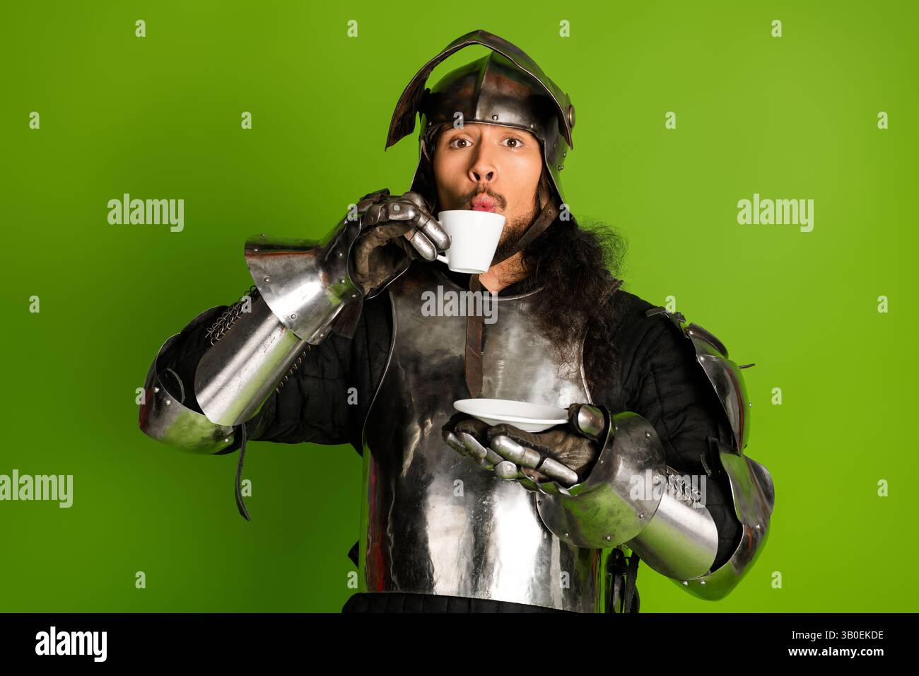 Knight in medieval armor drinking espresso against bright green ...