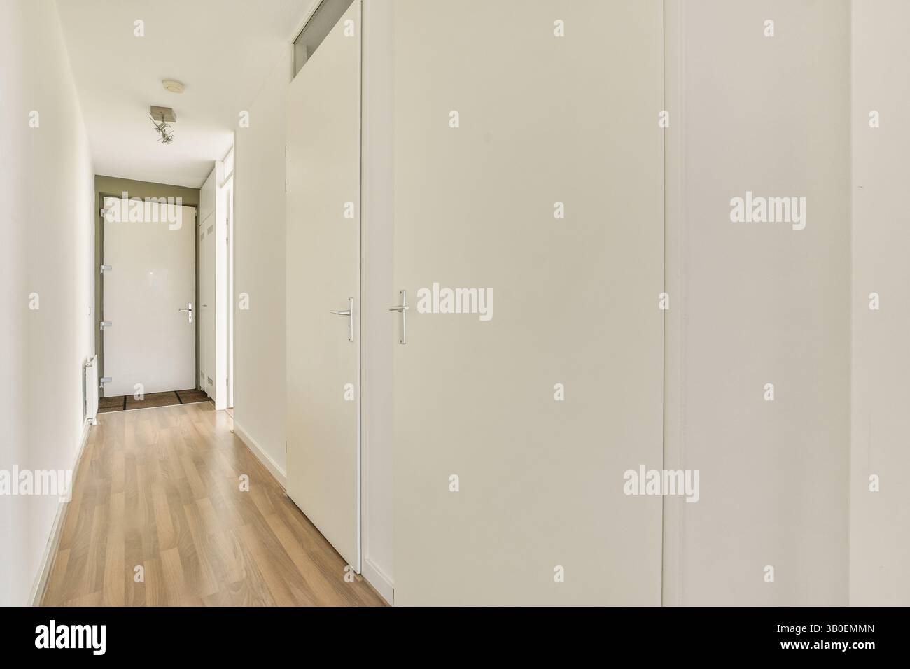 A bright and spacious hallway featuring clean white walls and a stylish ...