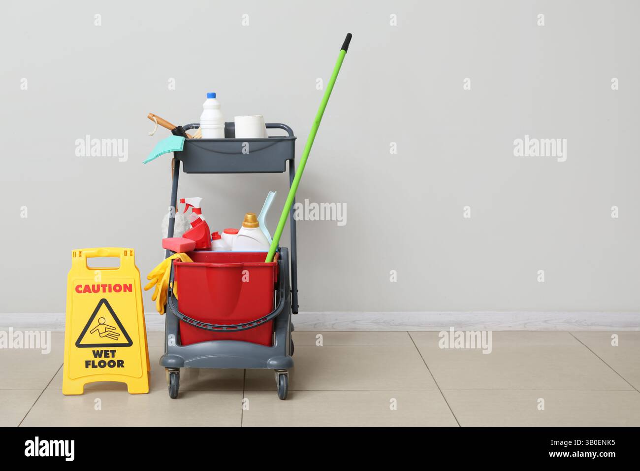 Caution sign with janitor's trolley indoors Stock Photo - Alamy