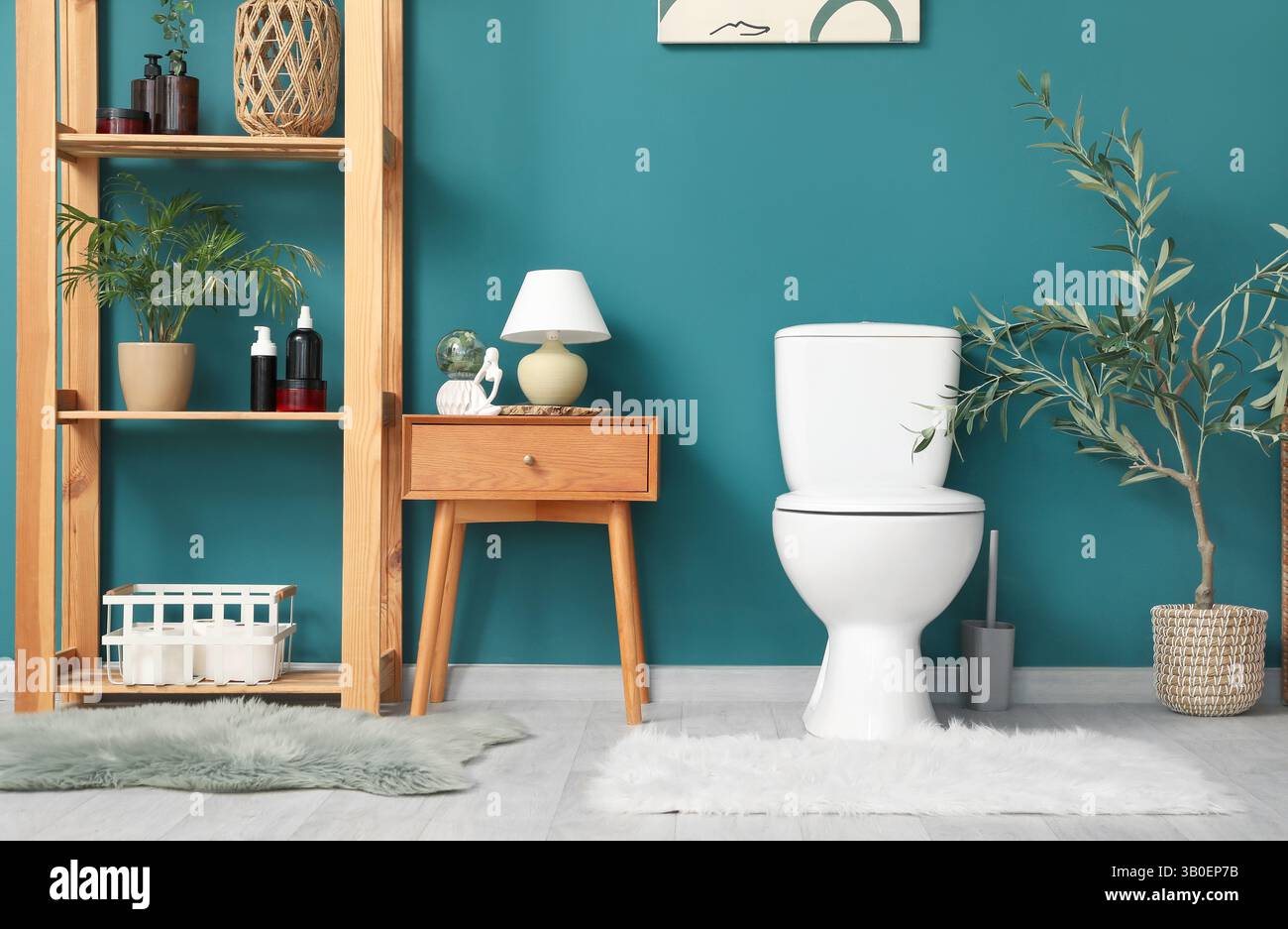 Interior of restroom with toilet bowl, table and shelf unit Stock Photo ...
