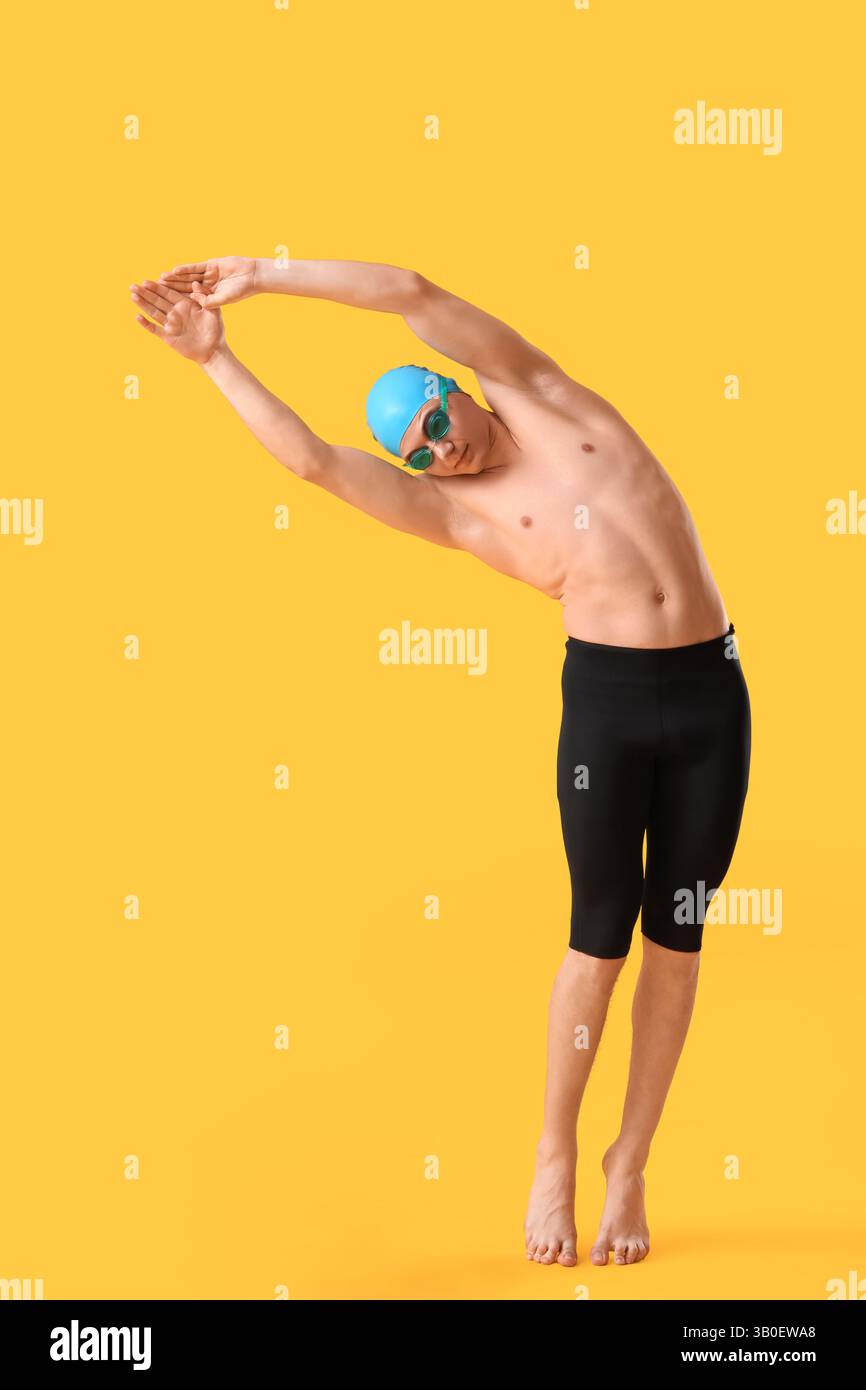 Male swimmer on yellow background Stock Photo - Alamy