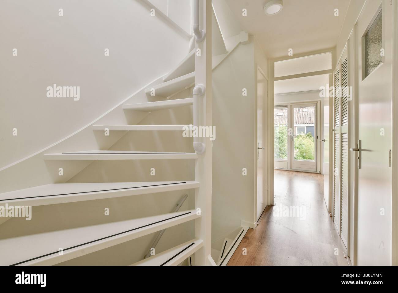 A stylish and well-lit interior featuring a modern staircase that leads ...