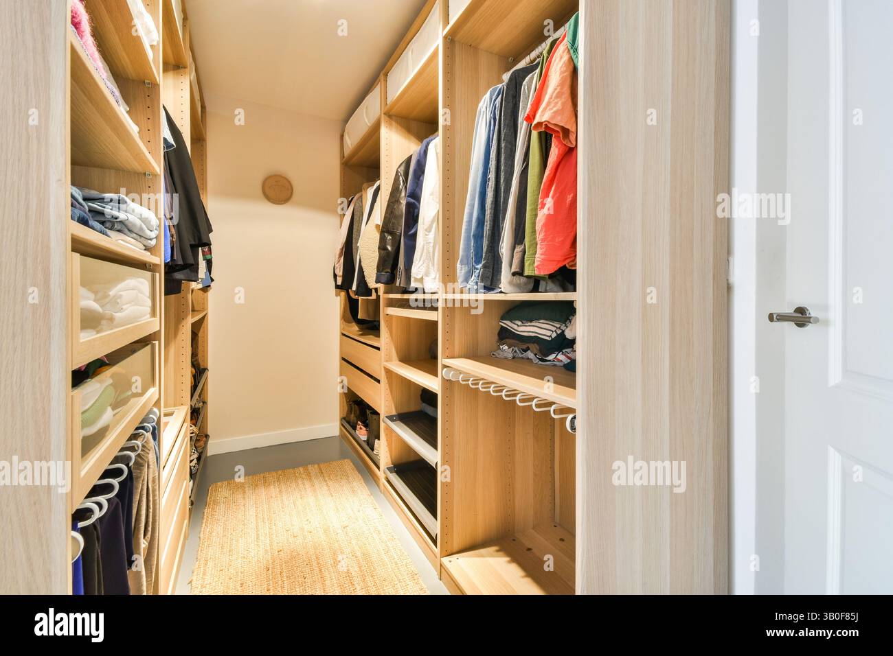 A well-organized modern closet featuring neatly arranged clothing and ...