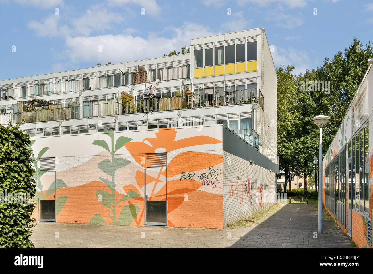 A contemporary building featuring vibrant artistic murals and lush ...