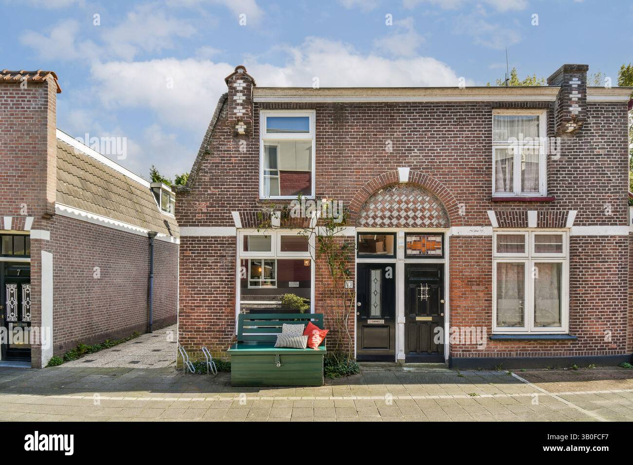 A picturesque brick house featuring large windows, an inviting entrance ...