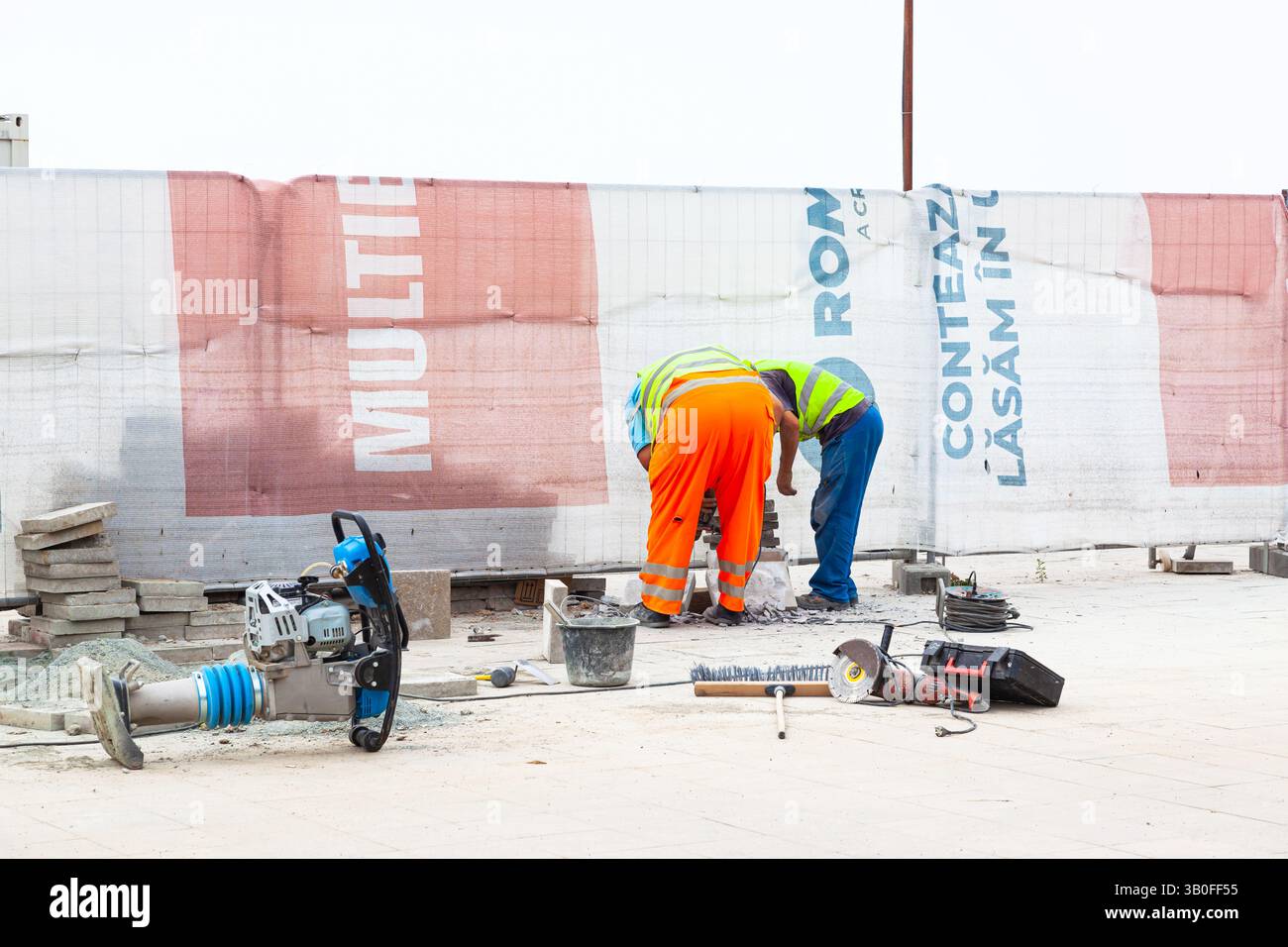 Road repair work involving people, laying new paving slabs Stock Photo ...