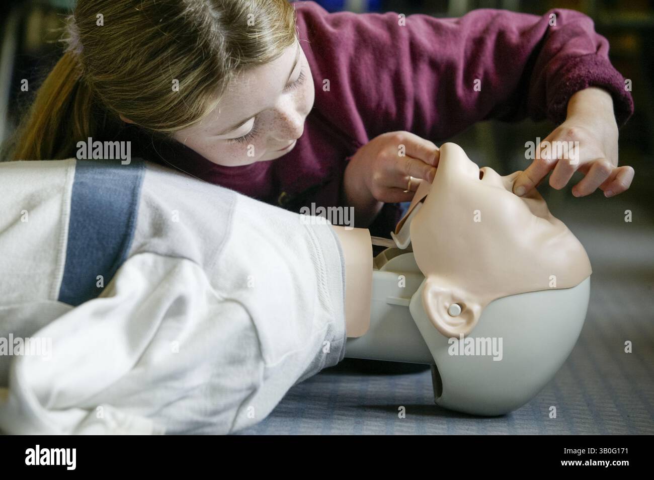 A UK primary school pupil practising life saving techniques on a dummy ...