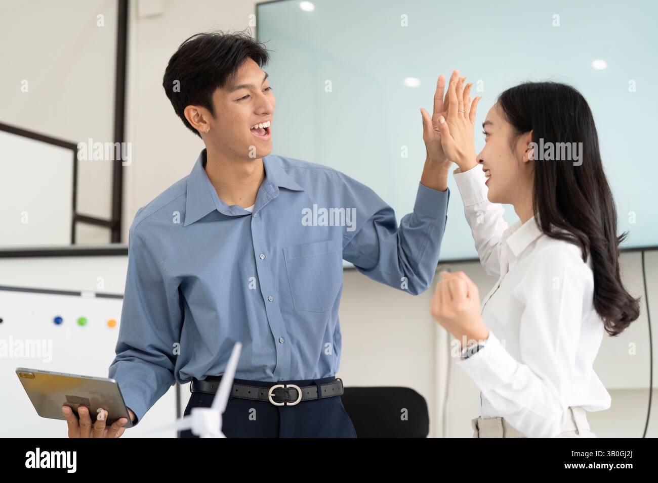 Team Collaboration and Success. Two professionals celebrating a successful project milestone ...