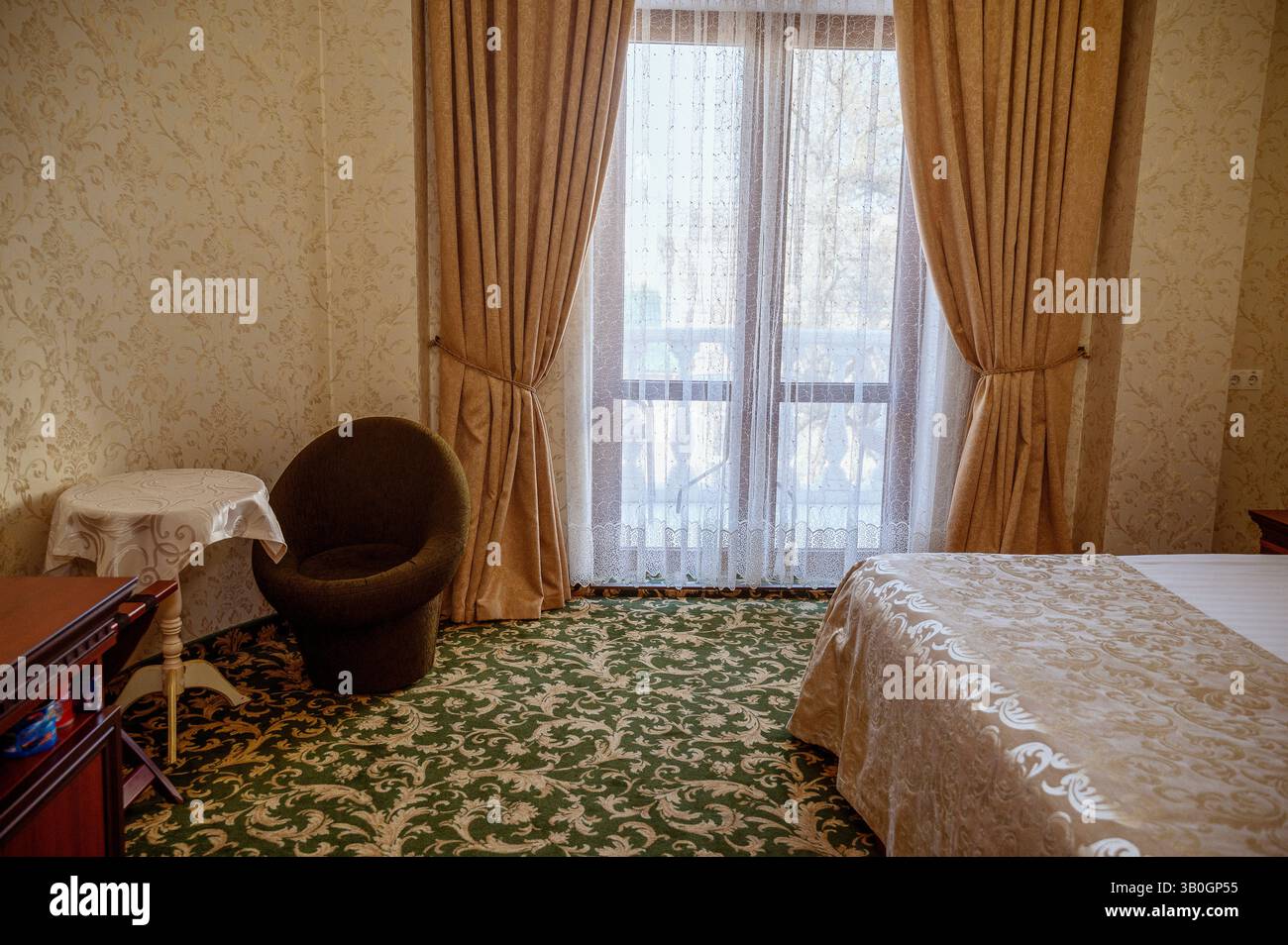 Hotel room with a large window, exit to the balcony. in the room table ...