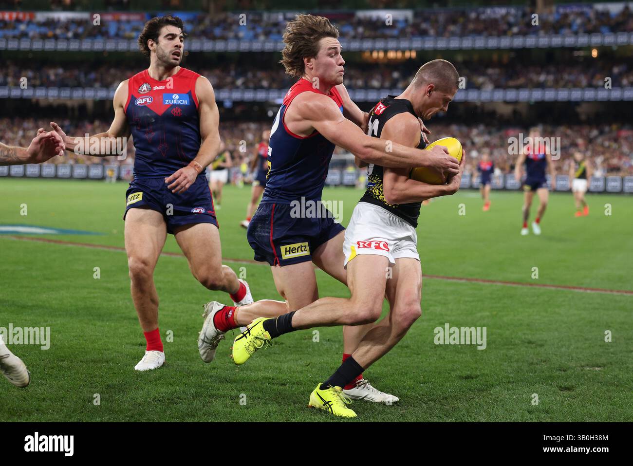 James Trezise of the Tigers is tackled by Tom Sparrow of the Demons ...
