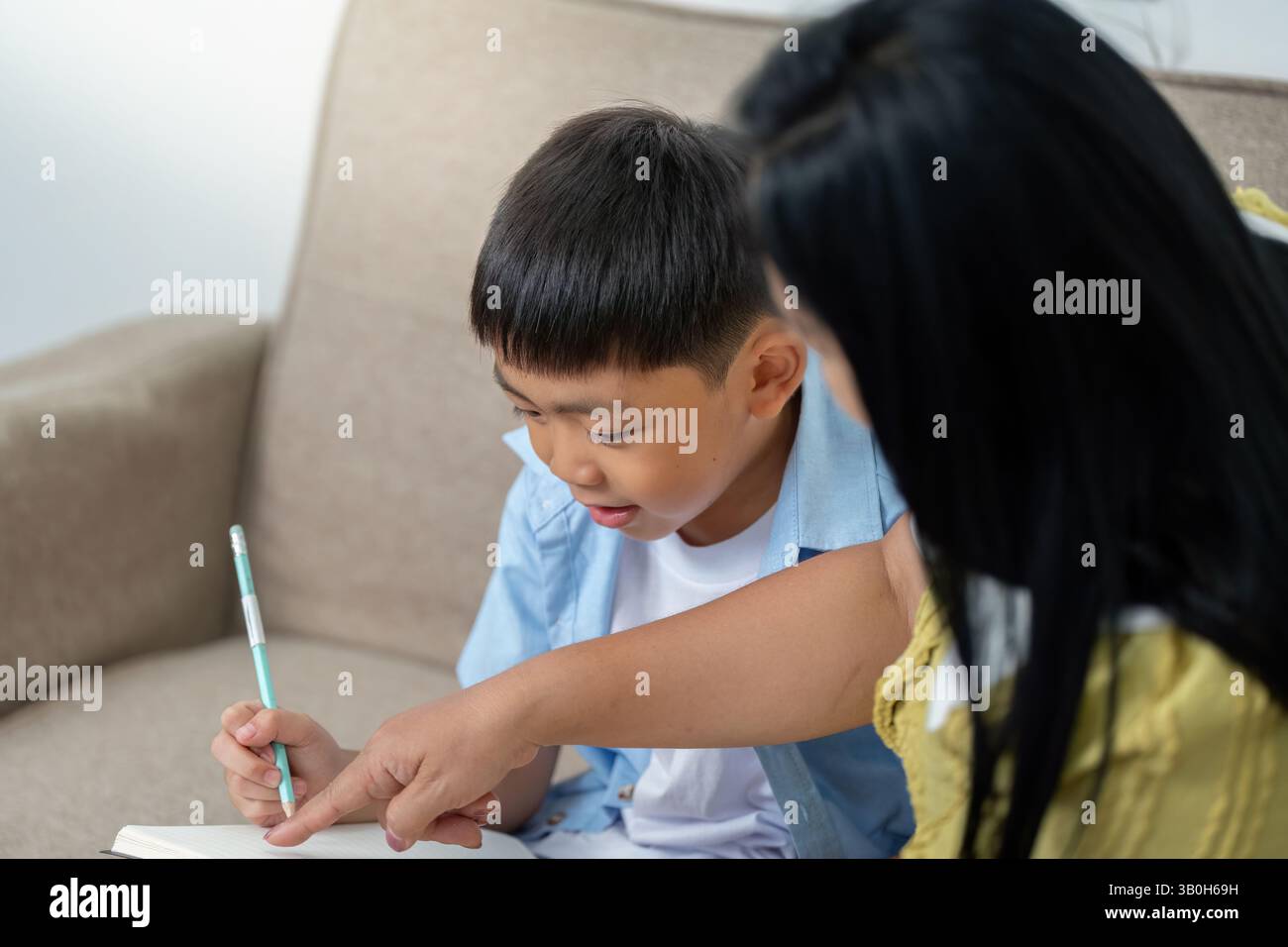 Back to School and Collaborative Learning. A mother guides her son as ...