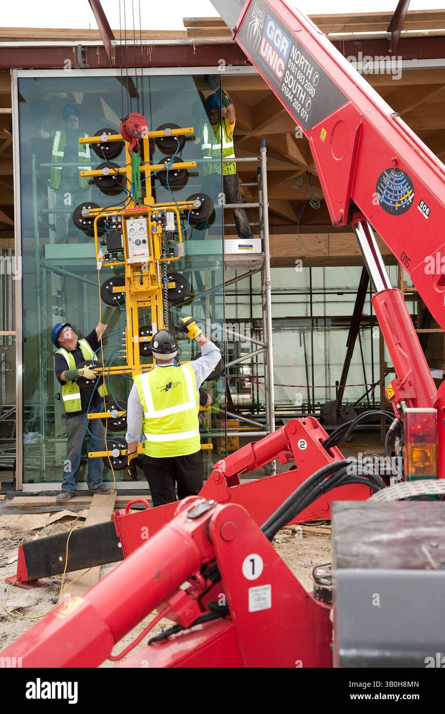 Installation of large glass panel on a building construction site Stock ...