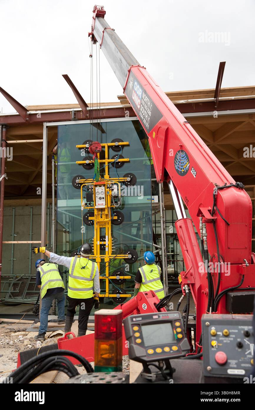 Installation of large glass panel on a building construction site Stock ...